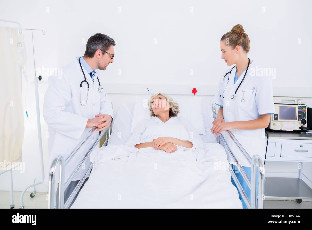 Doctors visiting a female patient in hospital Stock Photo - Alamy