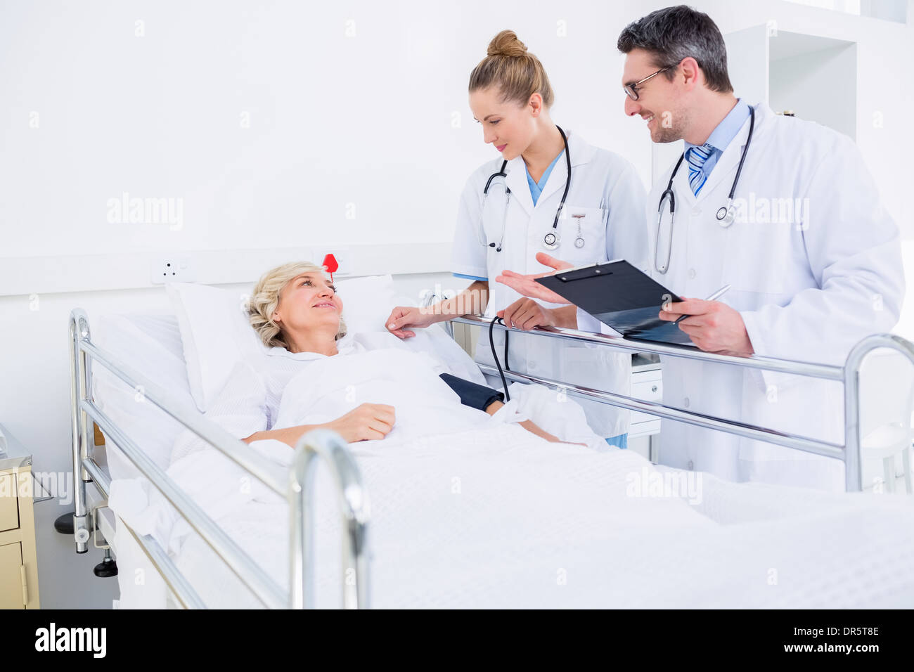Doctors visiting a female patient in hospital Stock Photo - Alamy