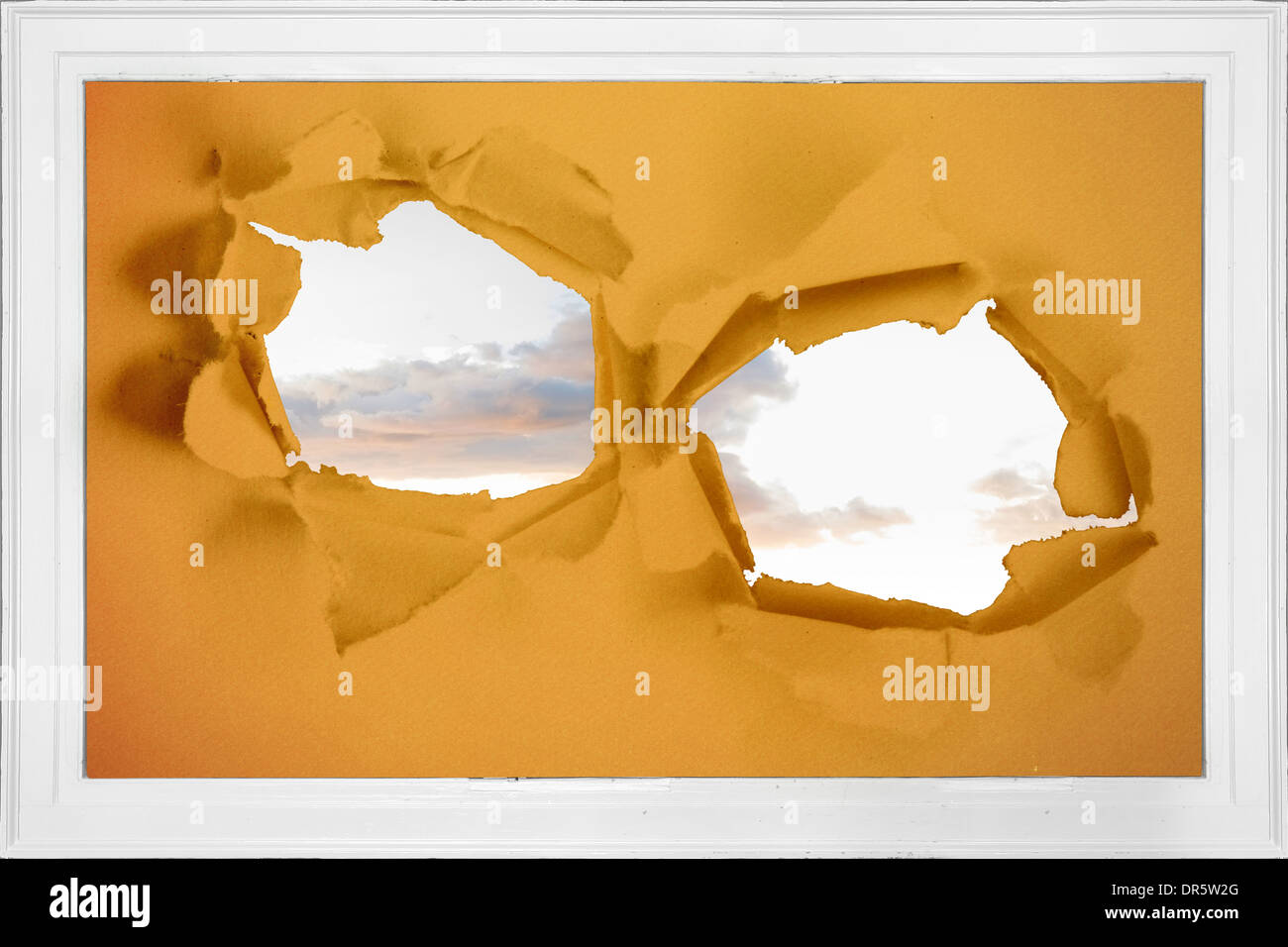 Rip on wall showing bright sky Stock Photo - Alamy