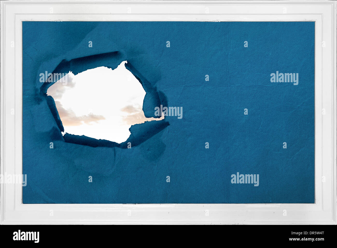 Rip on wall showing bright sky Stock Photo - Alamy