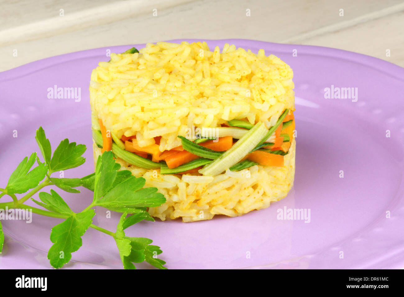 Saffron rice with crunchy vegetables, carrots and zucchini, served on a ...