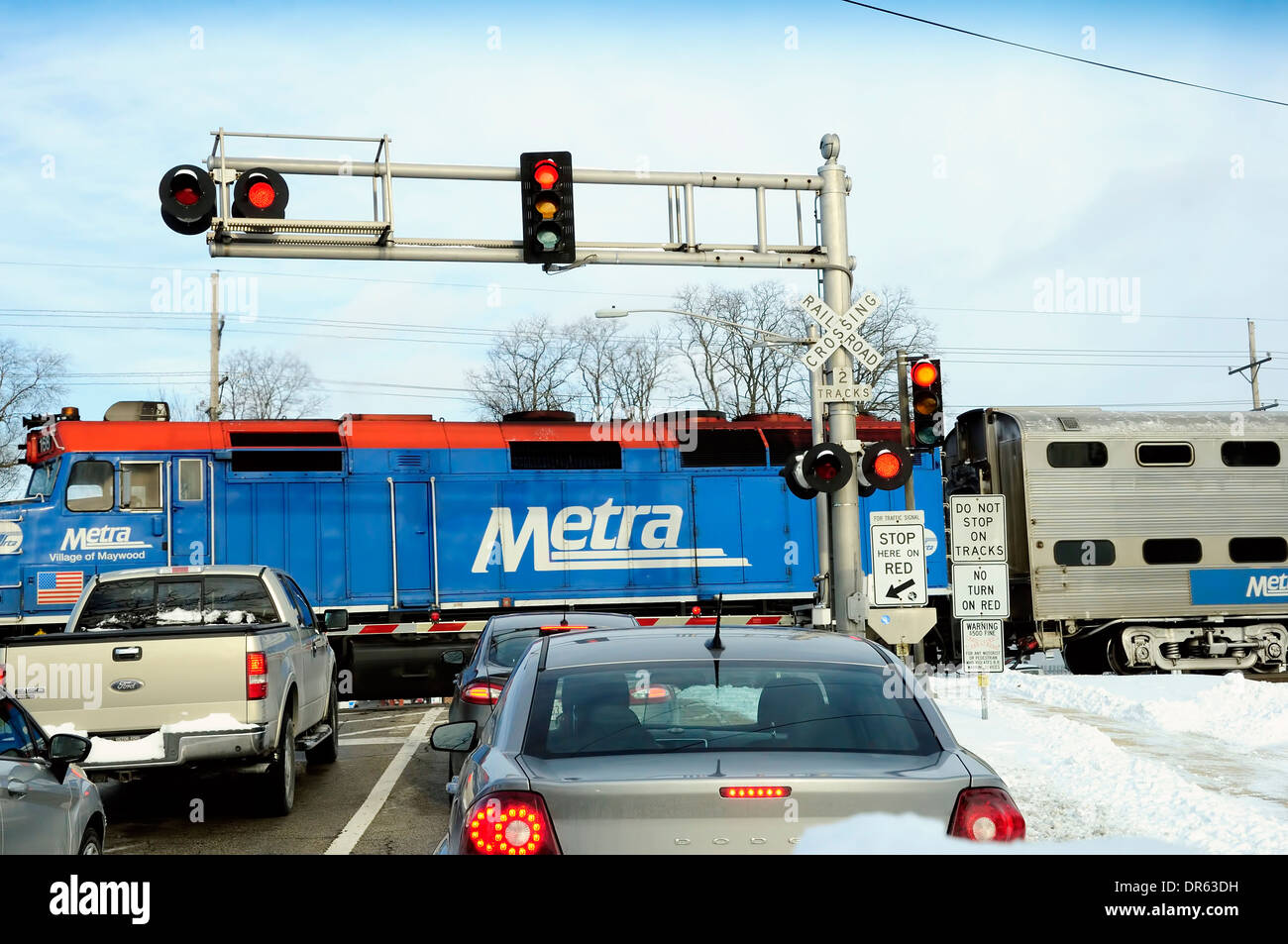 Commuter train engine speeds by Railroad crossing Stock Photo - Alamy
