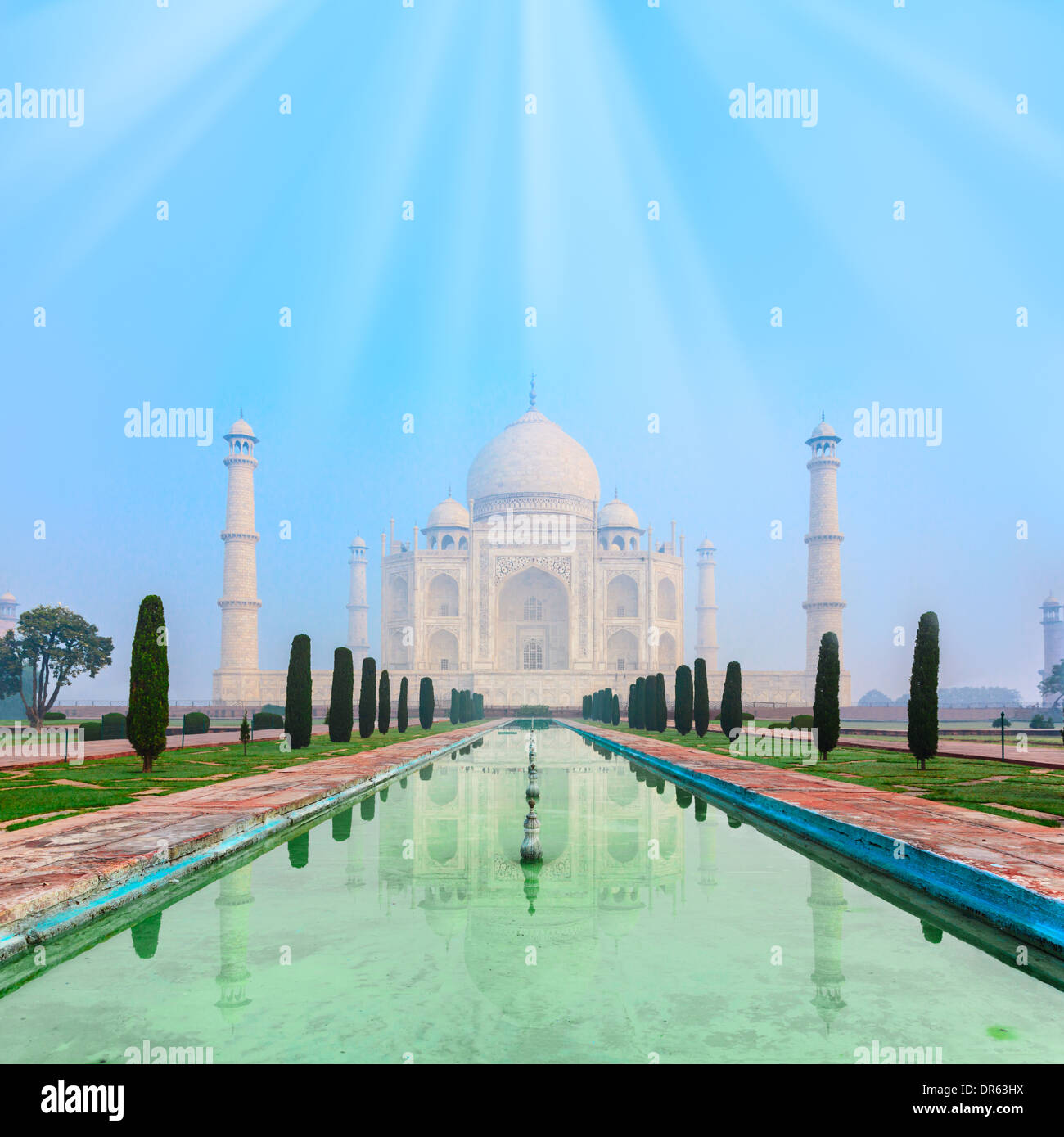 Taj Mahal in India with rays of Sun through pale morning mist, text ...