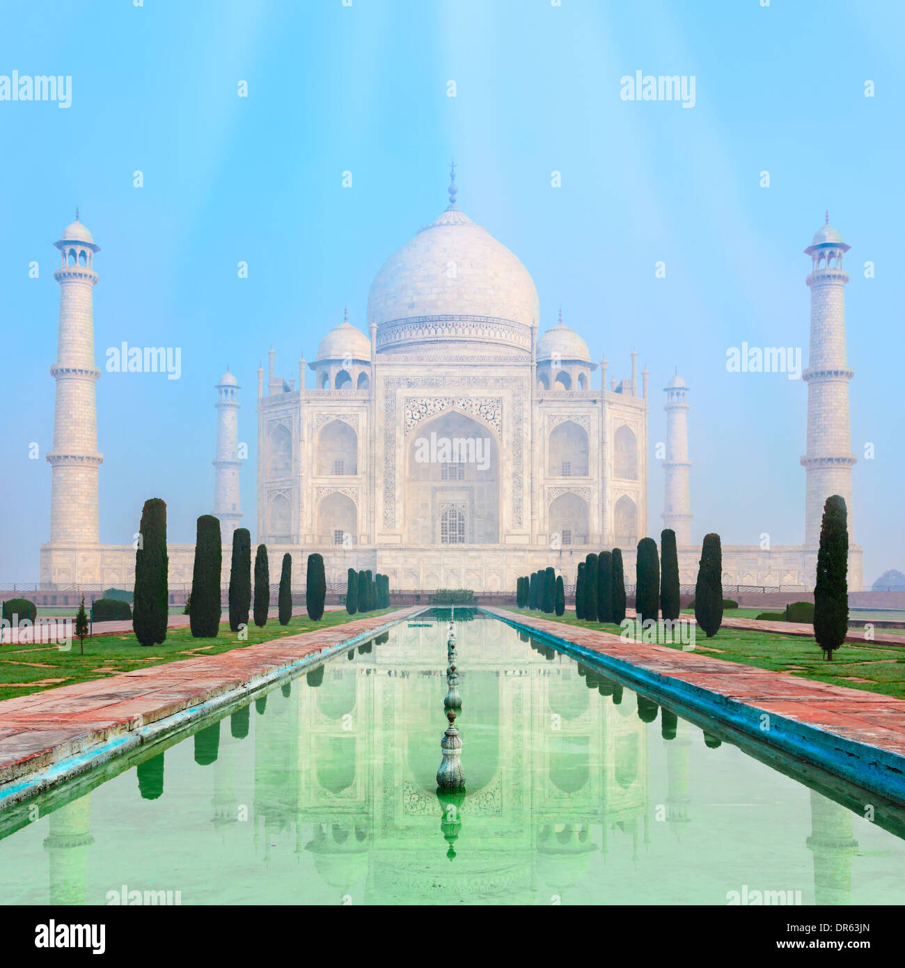 Taj Mahal in India with rays of Sun through pale morning mist, text ...