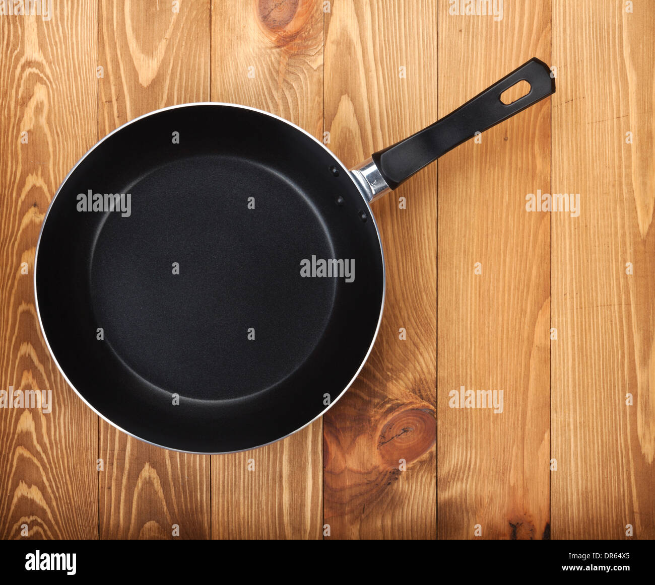 Frying pan on wooden table background. View from above Stock Photo - Alamy