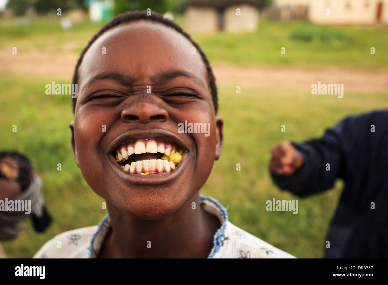 Portrait of face of smiling young African boy showing off teeth and ...
