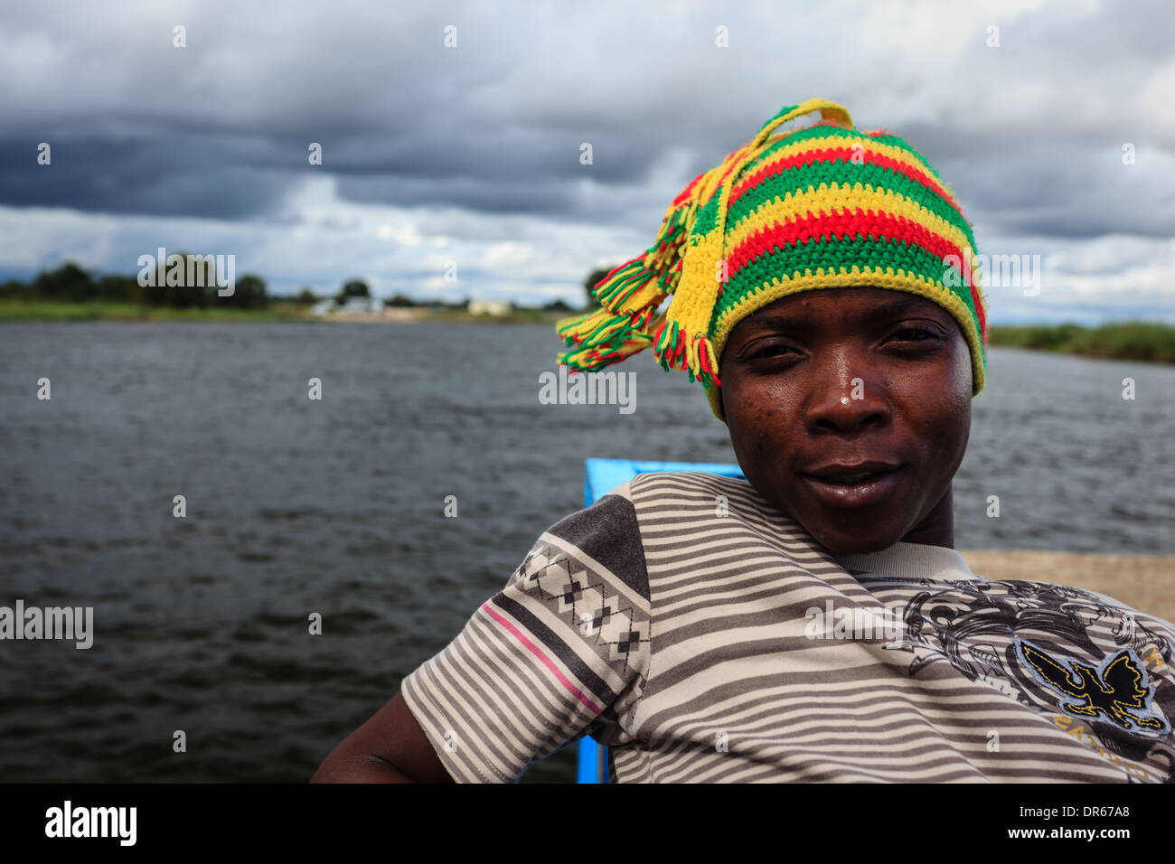 Portrait of young African boy with knit hat in boat on the river in the ...