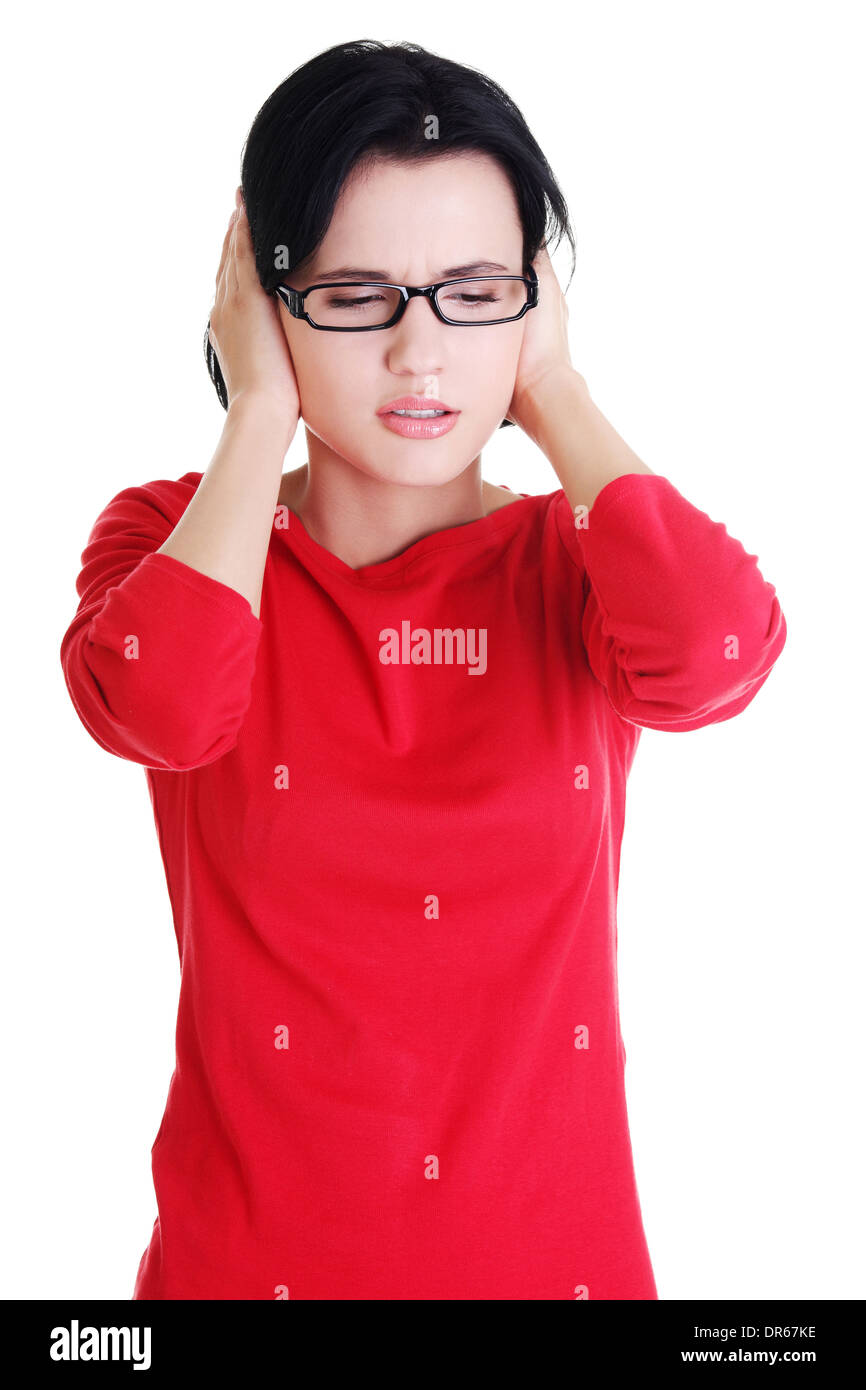 Closeup of frustrated young woman holding her ears, isolated on white ...