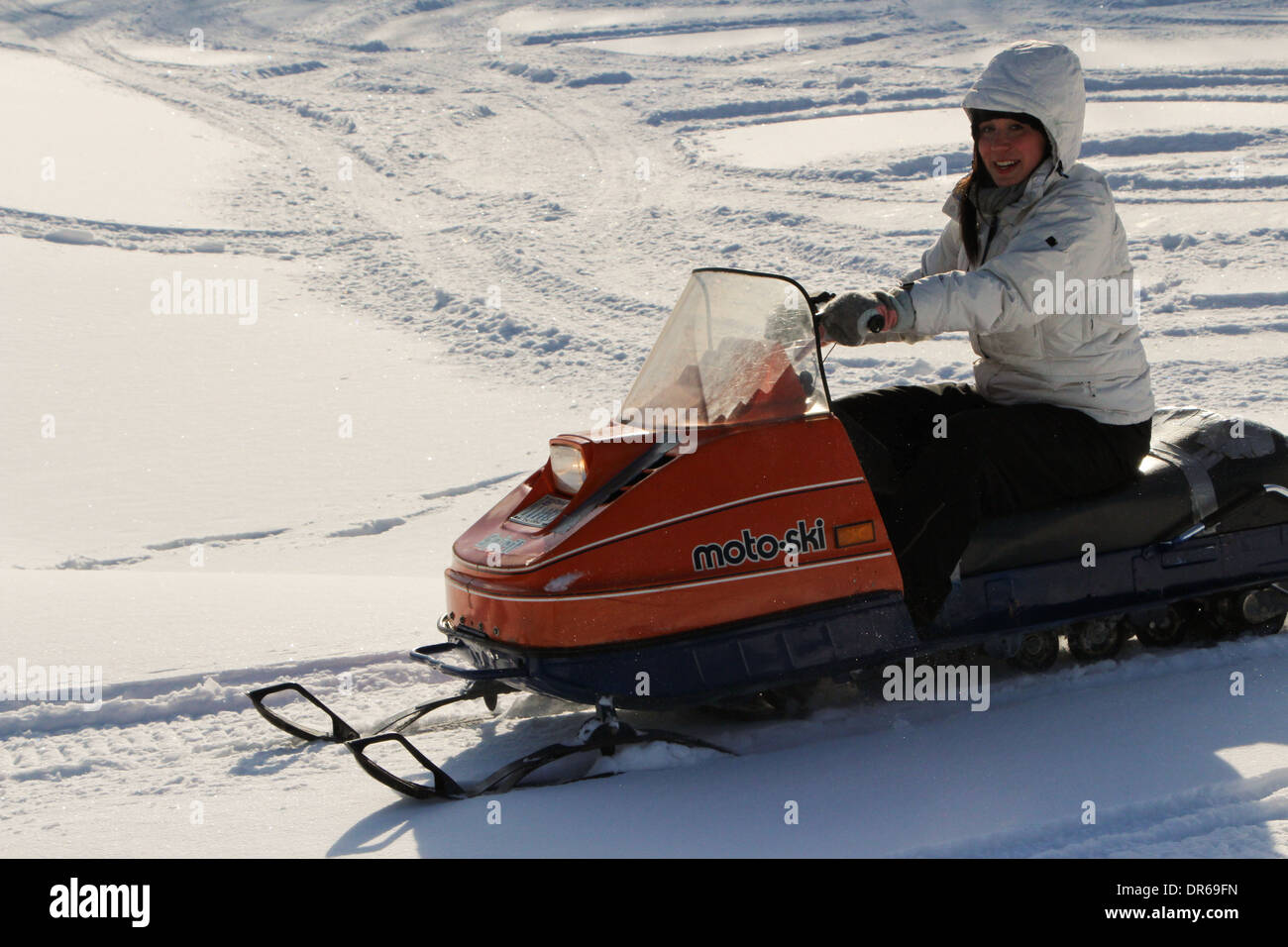 A woman in her early 30s enjoying a snowmobile ride after a fresh ...