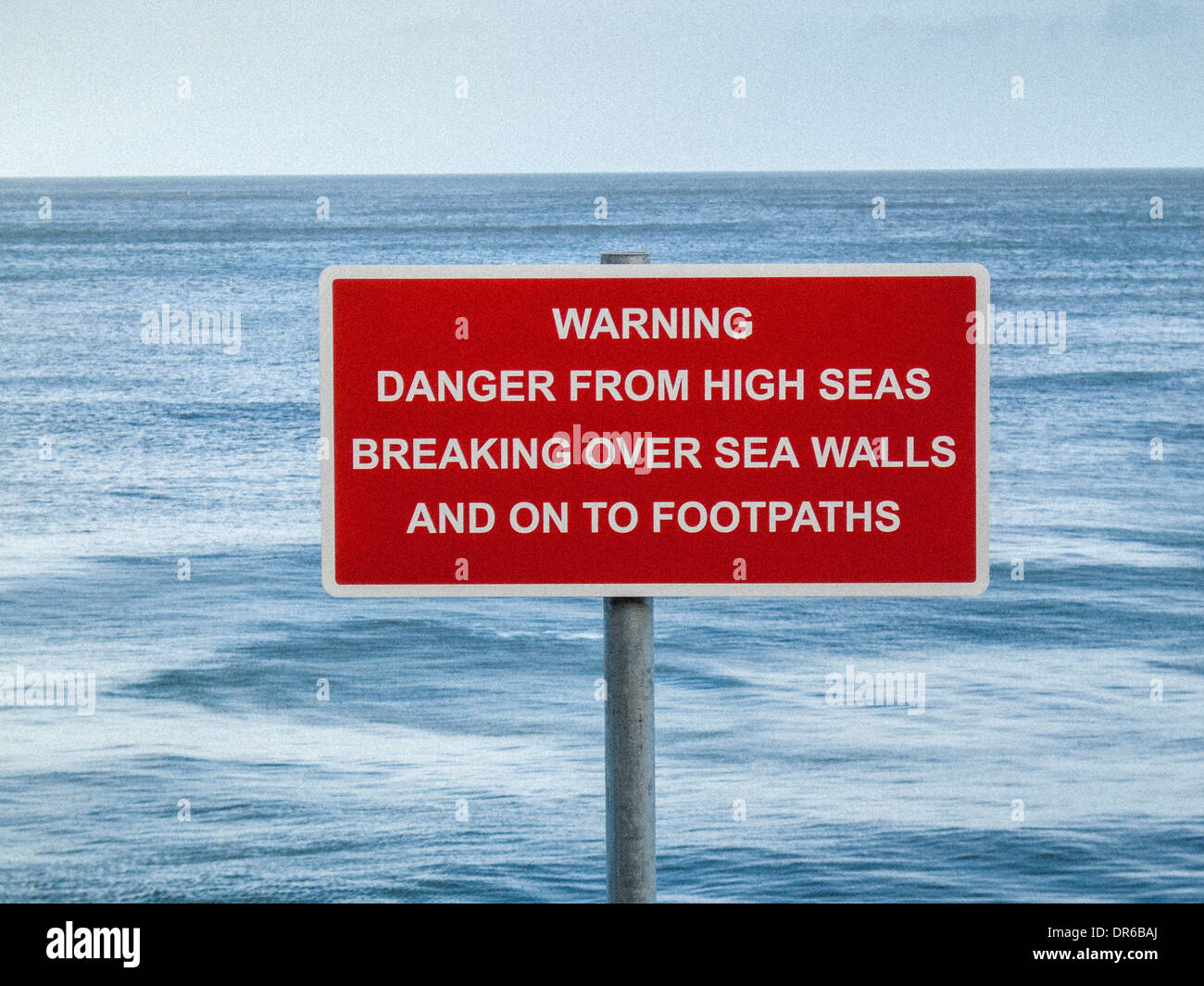 Red warning sign: Danger from high seas breaking over sea walls and on ...
