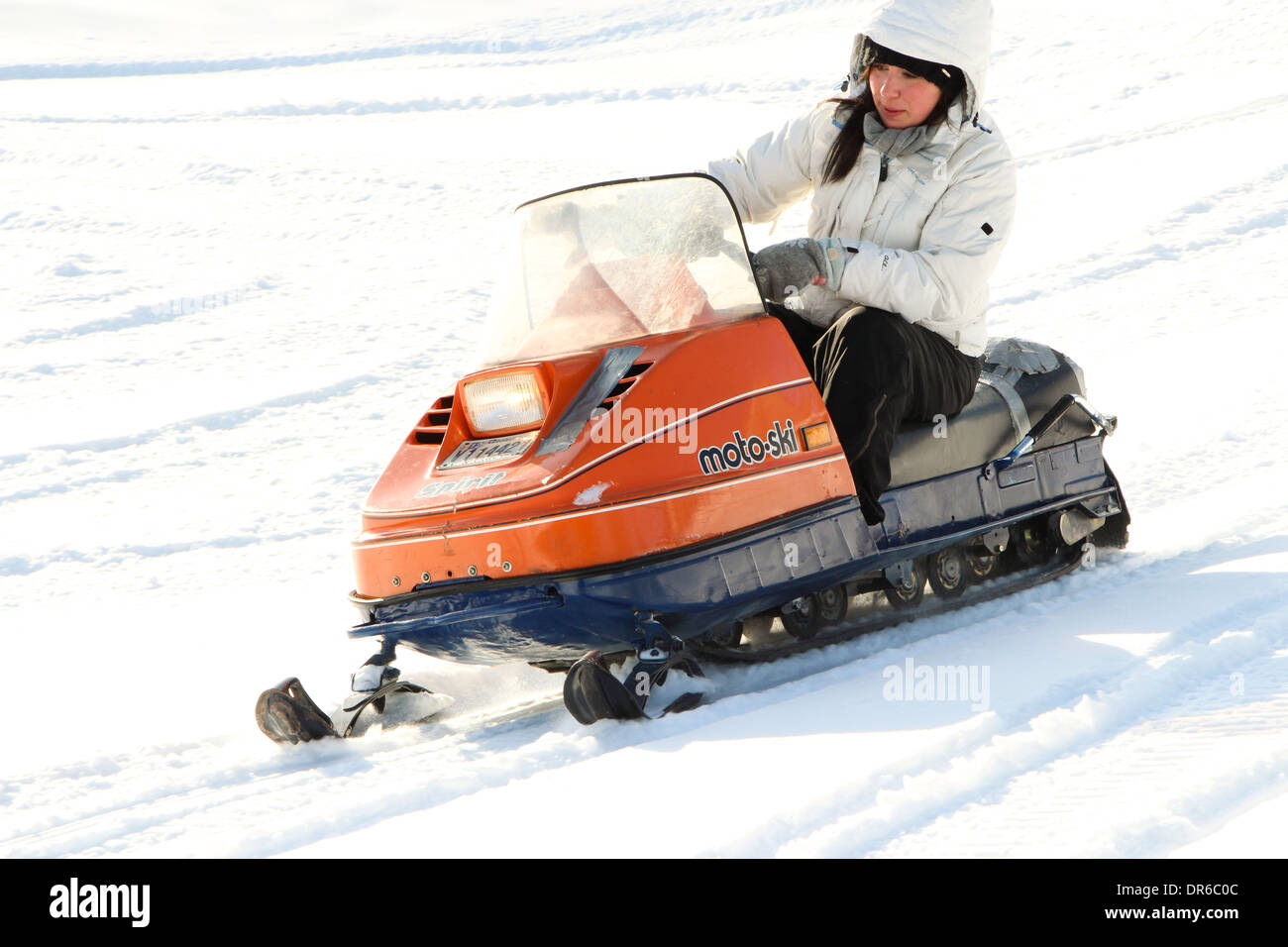 A woman in her early 30s enjoying a snowmobile ride after a fresh ...