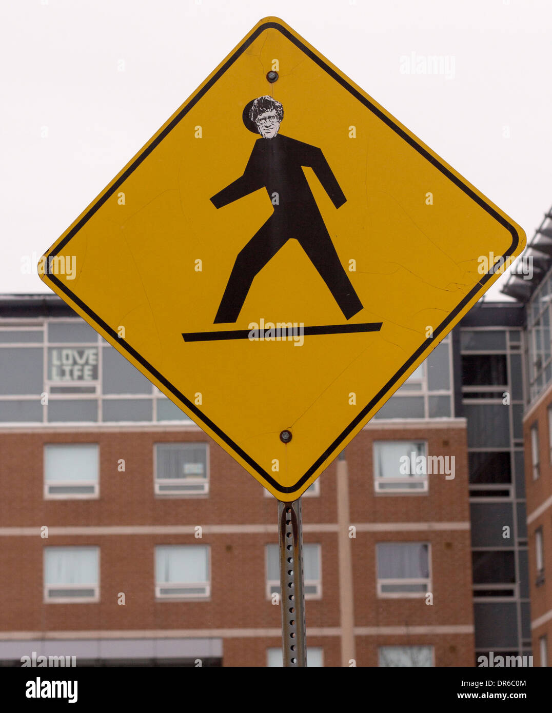 Pedestrian waling sign with a face stuck to the sign Stock Photo - Alamy