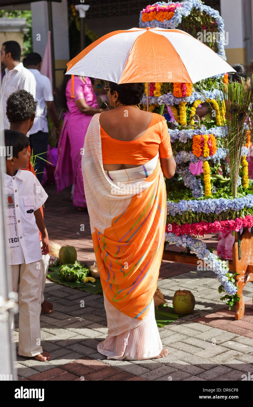 A woman wearing a colourful saree at a Tamil temple during the ...
