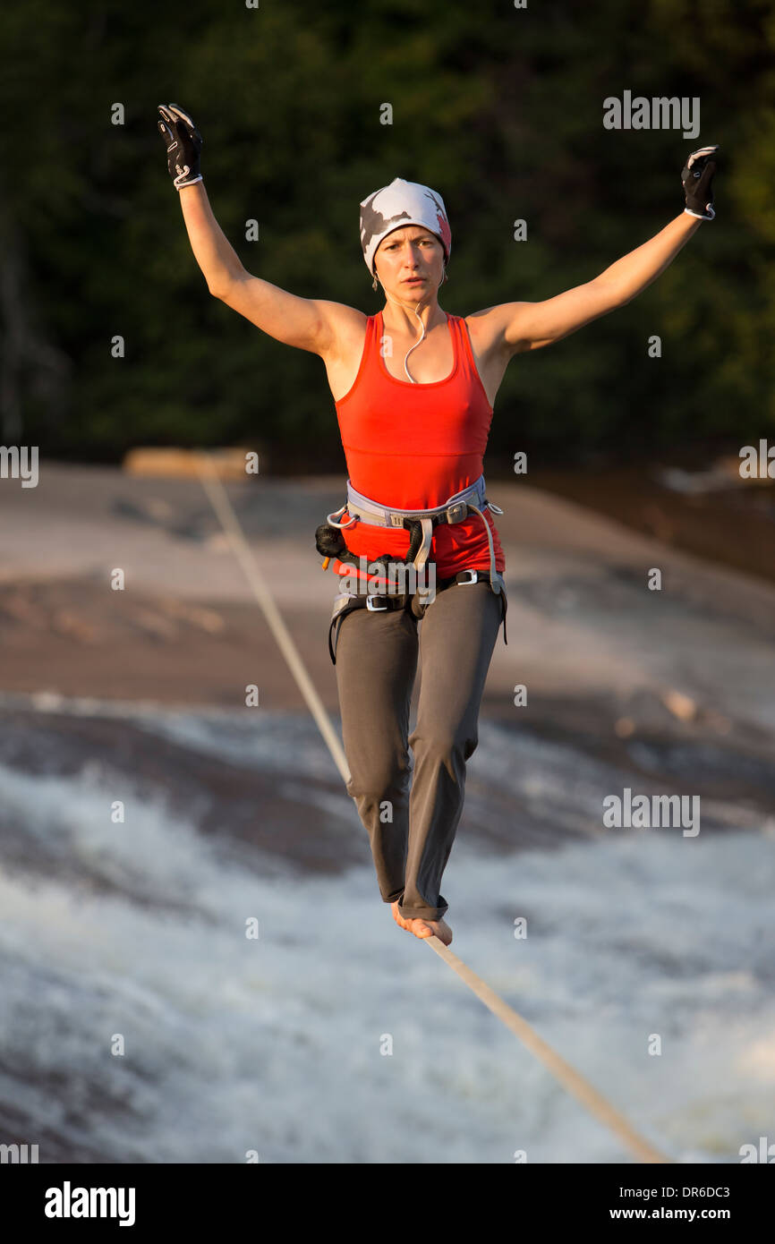 Female slackliner walking a slackline that spans a river Stock Photo ...