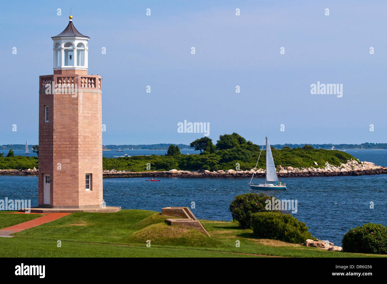 Sailboat passes by Avery Point lighthouse on the Thames River. It is ...