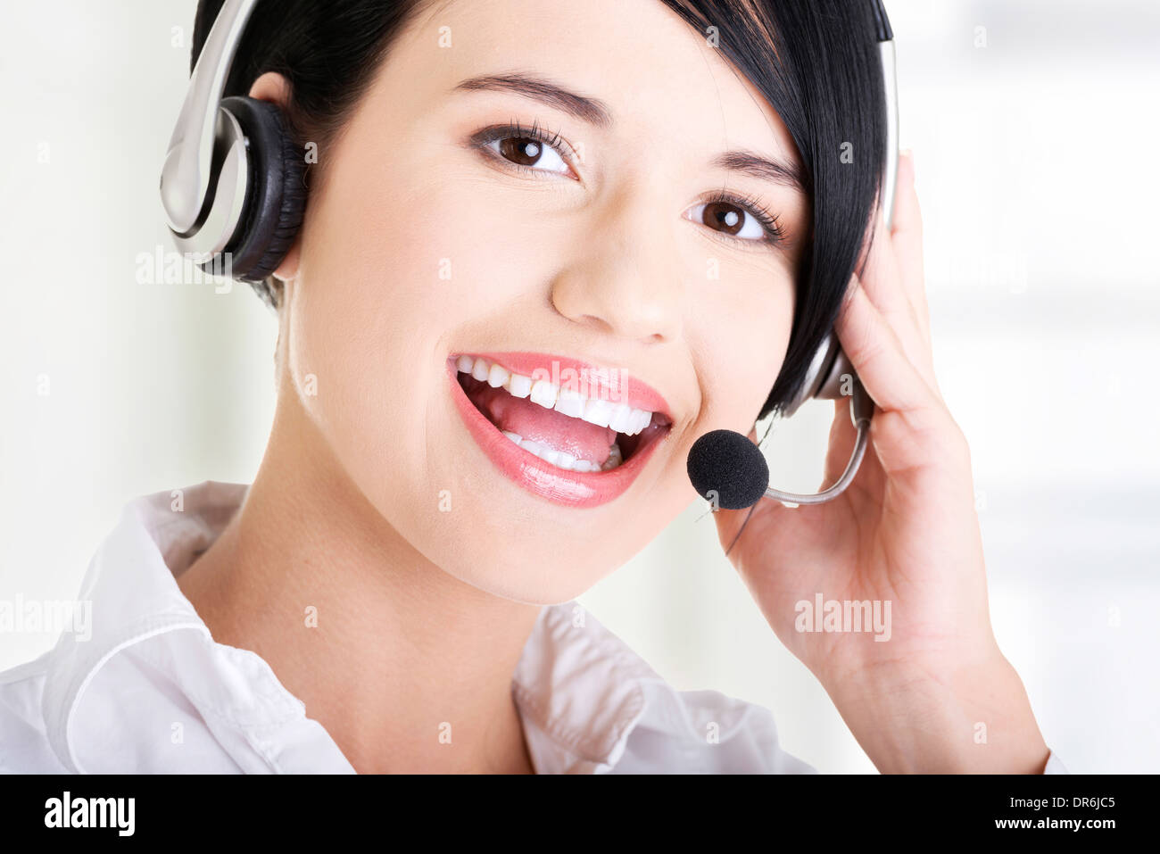 Beautiful young call-center assistant smiling at the camera Stock Photo - Alamy