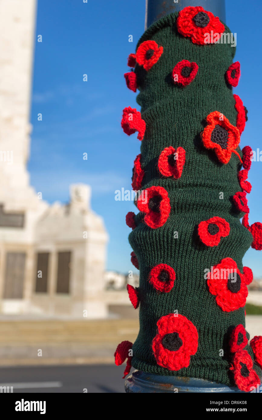 Hand crochetted and knitted red poppies on lamp post in front of the ...