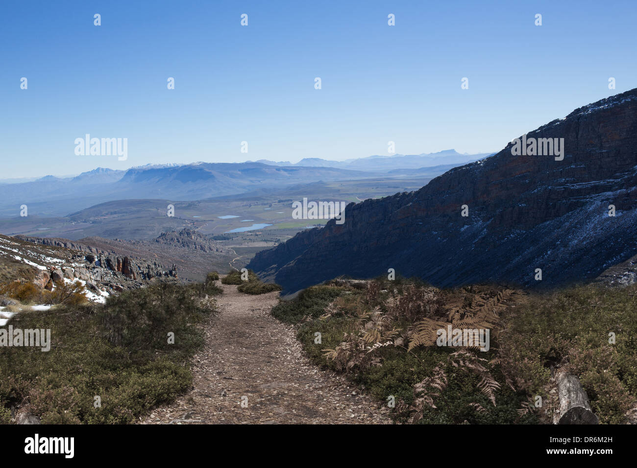 Path leading down into valley under bright sky Stock Photo - Alamy