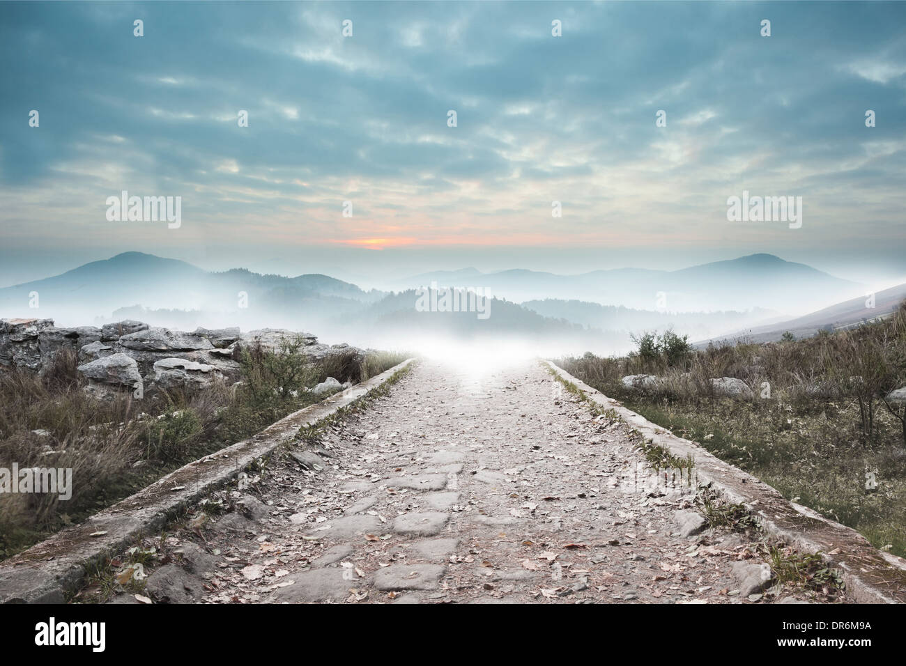 Stony path leading to misty mountain range Stock Photo - Alamy