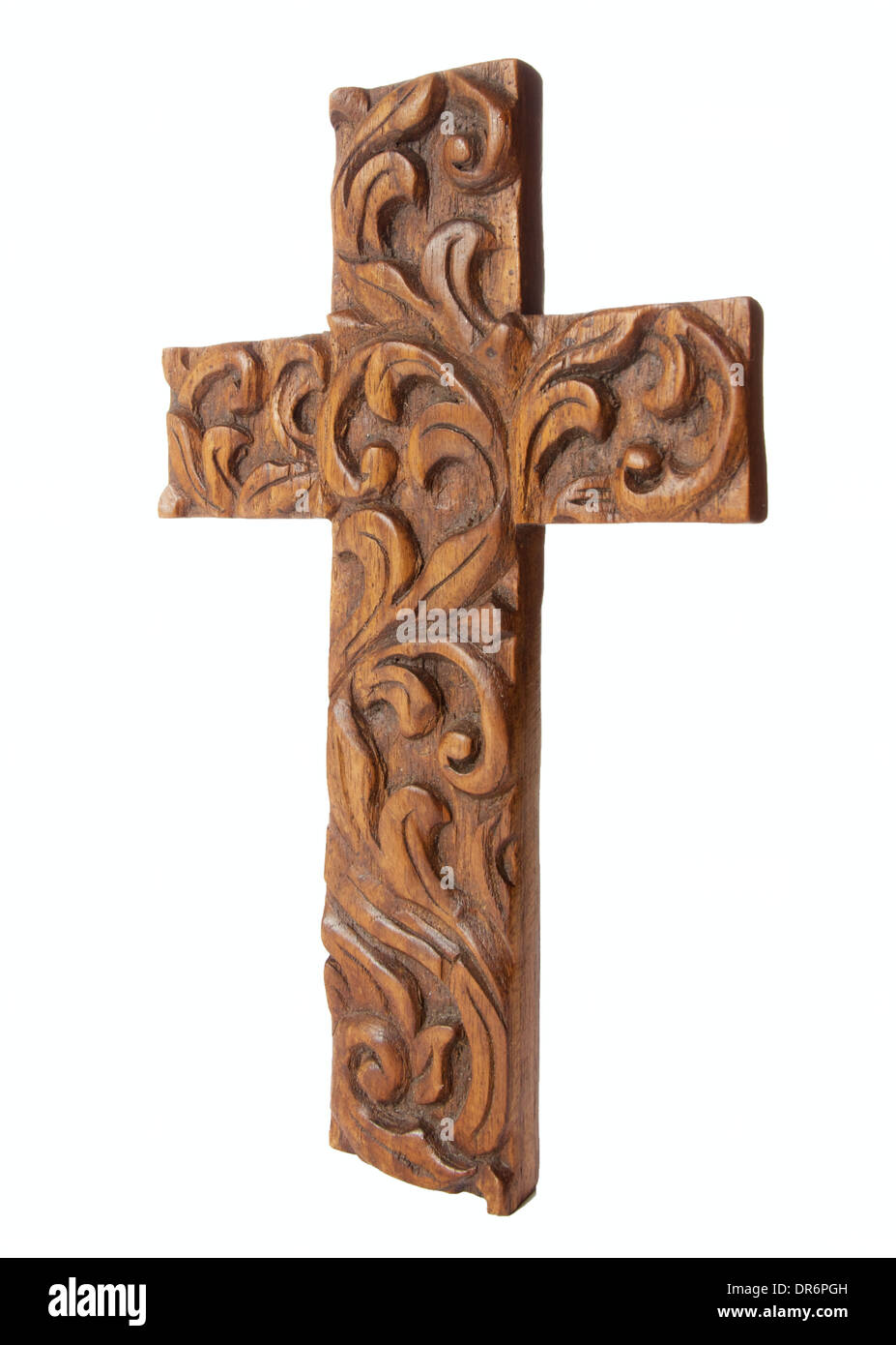 ornate, hand carved wooden cross on a white background at angled view ...