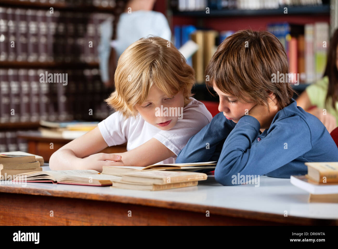 Little Boys Reading Book Together In Library Stock Photo - Alamy