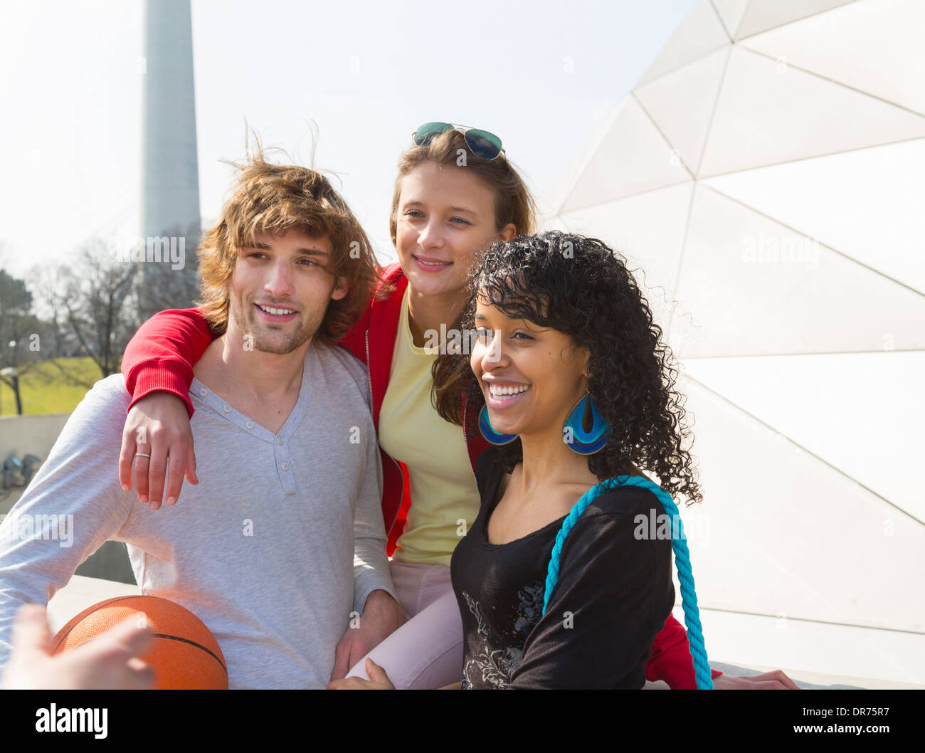 Germany, Bavaria, Munich, Three friends having fun at the Olympic Park ...