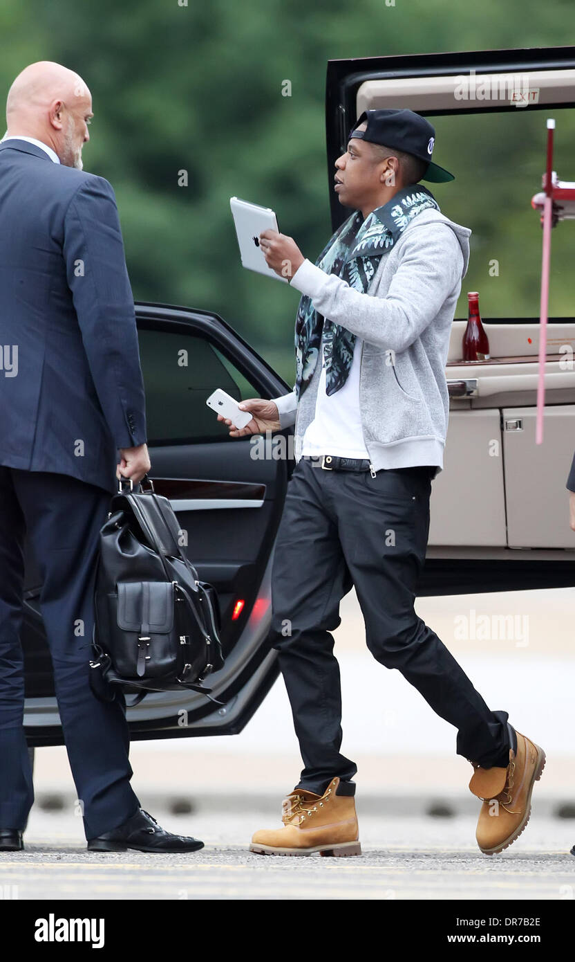 Jay Z clutches both an iPad and an iPhone as he flies into the car park ...