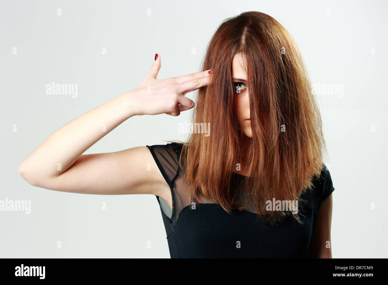 Young depressed woman shooting herself with finger Stock Photo - Alamy