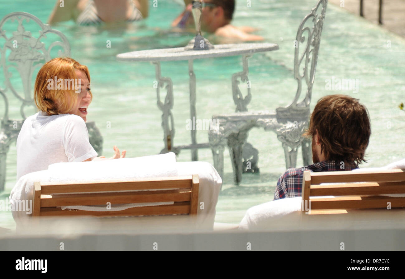 Miley Cyrus and Cheyne Thomas spend some time relaxing at the pool ...