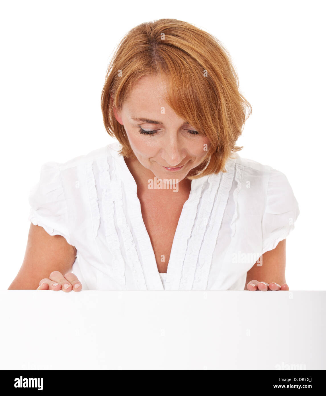 Middle aged woman standing behind white placeholder. All on white ...