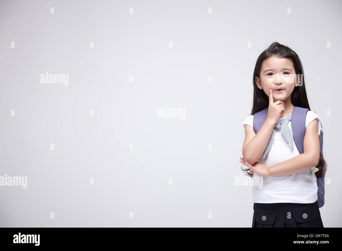 a girl wearing a school bag posing in white background Stock Photo - Alamy
