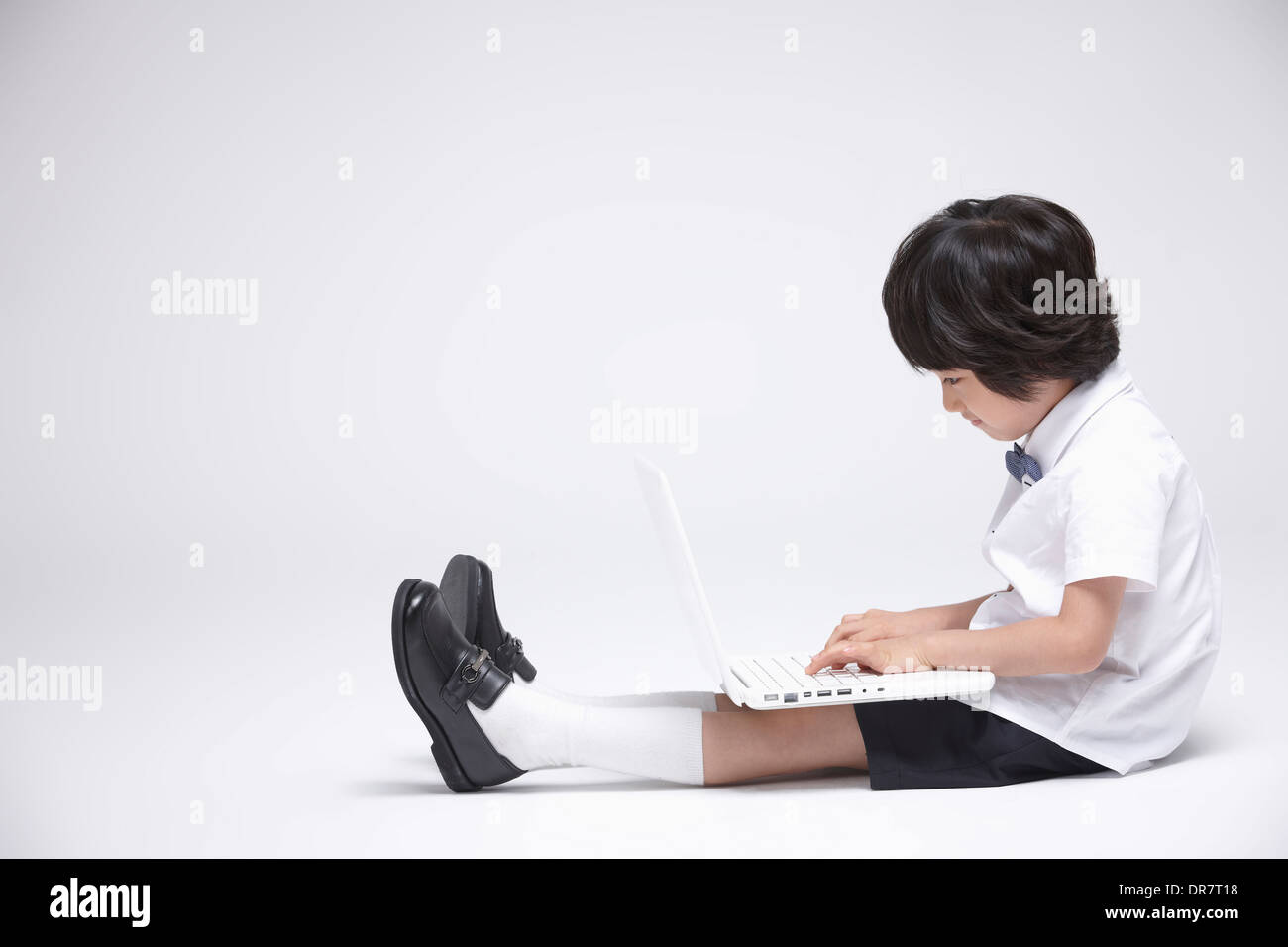 Boy school uniform sitting on floor hi-res stock photography and images ...