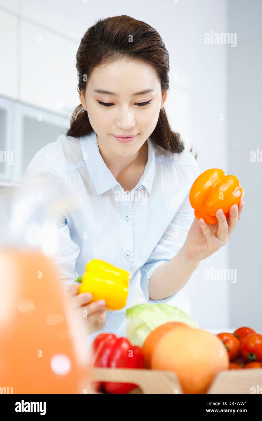 a woman putting vegetables and fruits on a tray Stock Photo - Alamy