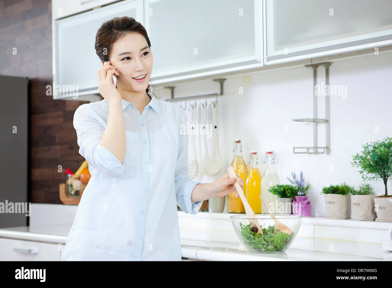 a woman talking on the phone while cooking Stock Photo - Alamy