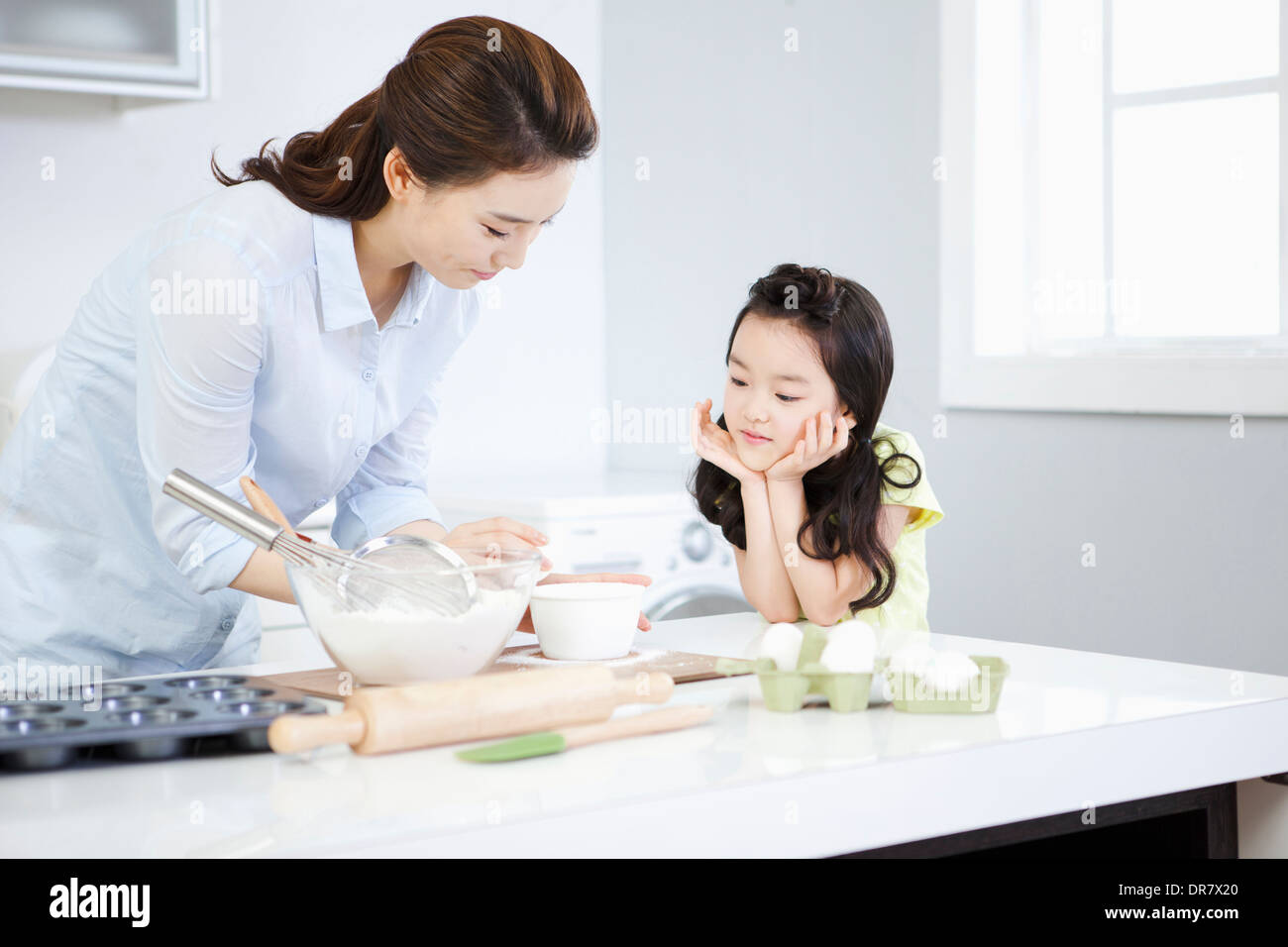 a daughter watching mother cooking Stock Photo - Alamy