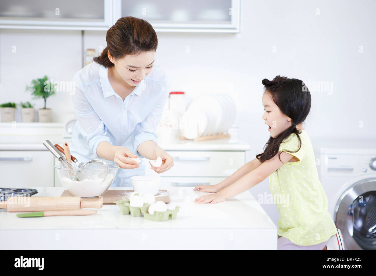 a daughter watching mother cooking Stock Photo - Alamy