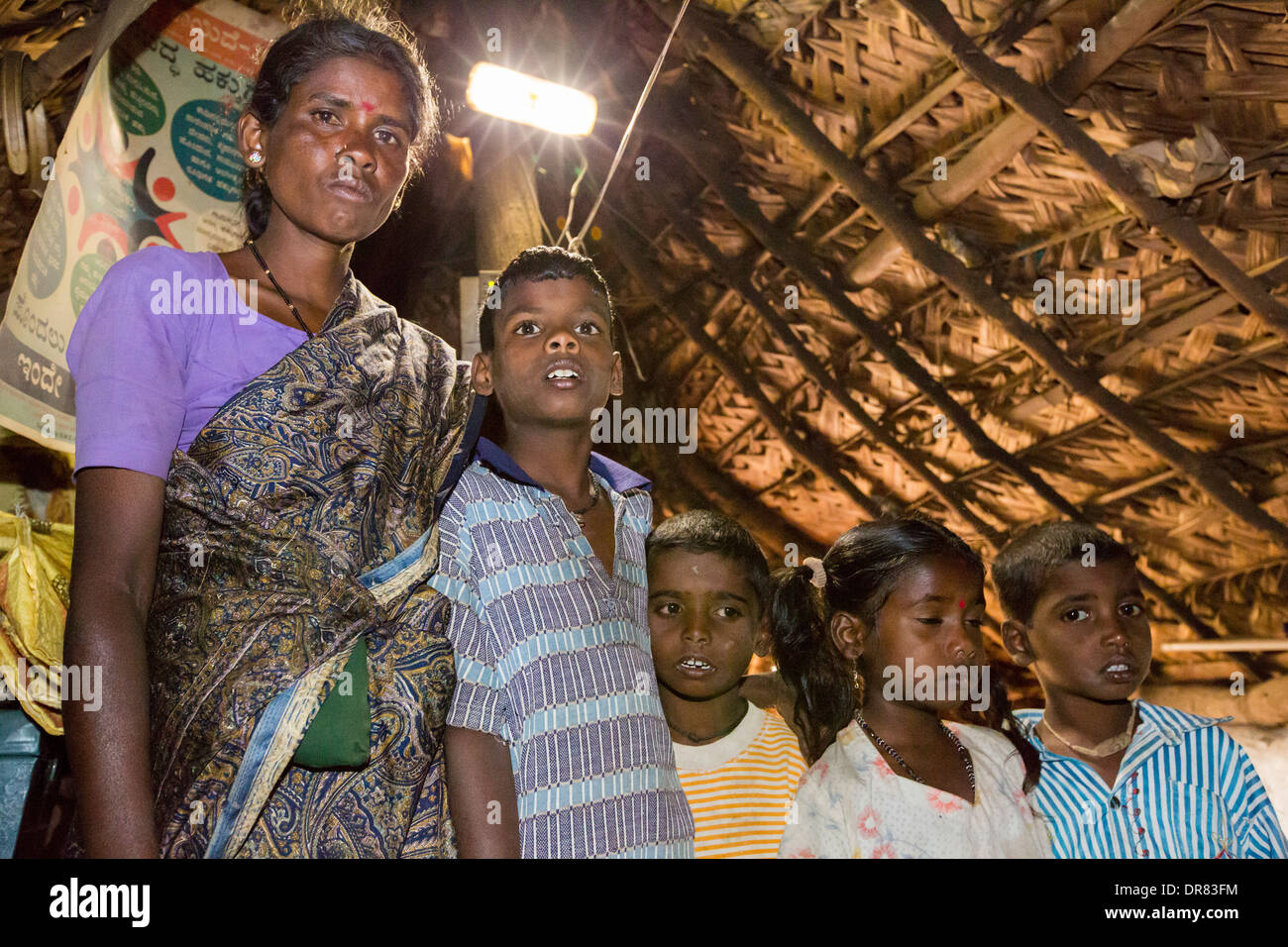 An untouchable woman in her hut, illuminated by an electric light ...