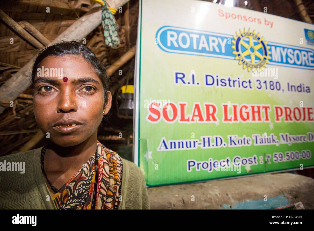 An untouchable woman in her hut, illuminated by an electric light ...