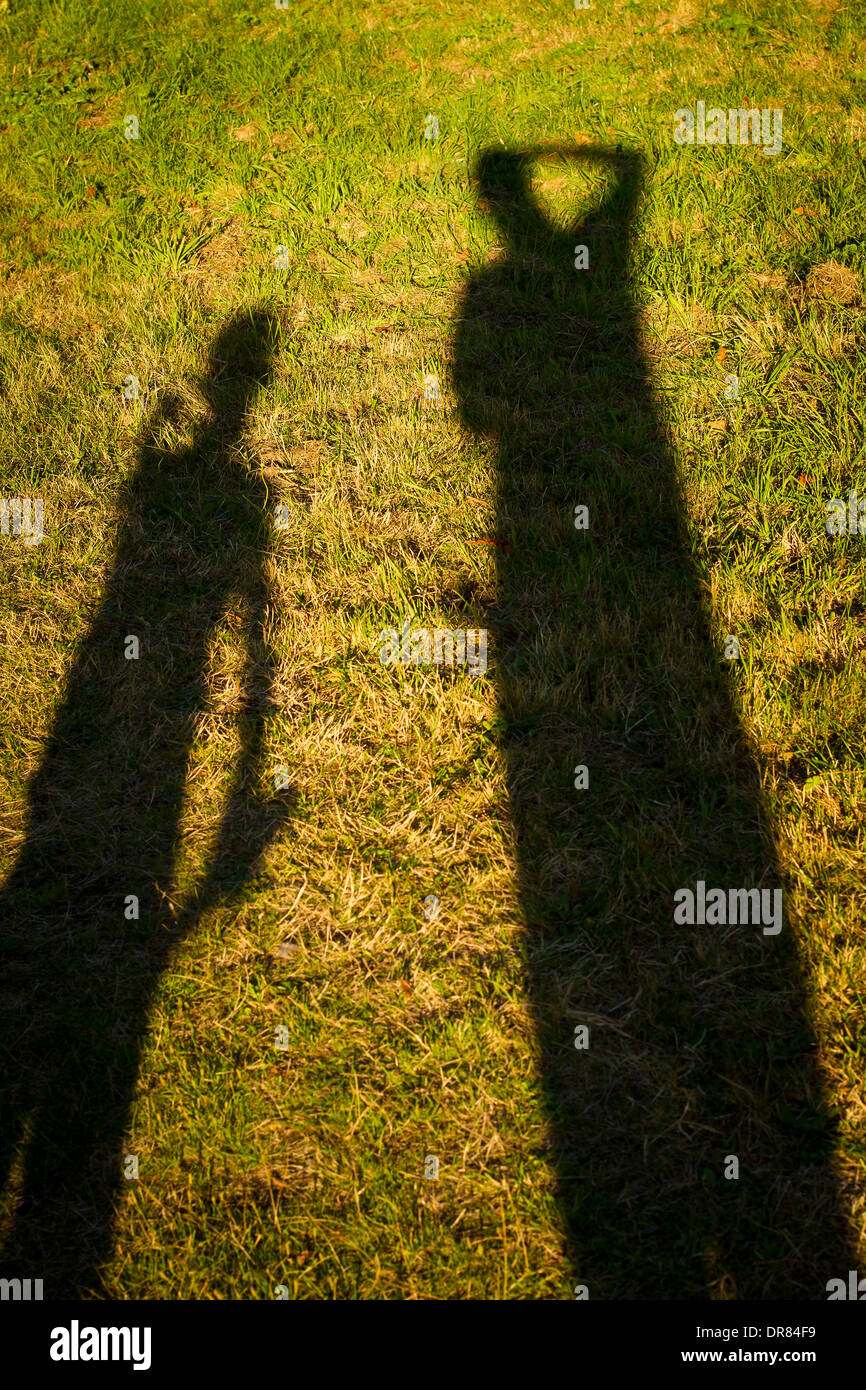 Two people's shadows on the grass Stock Photo - Alamy