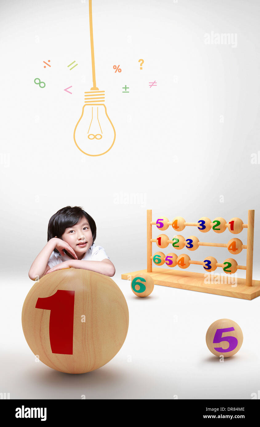 a boy leaning on a ball with number one sign Stock Photo - Alamy