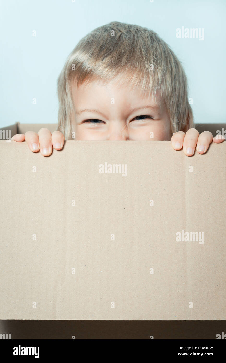 Portrait of boy (4-5) sitting in box Stock Photo - Alamy