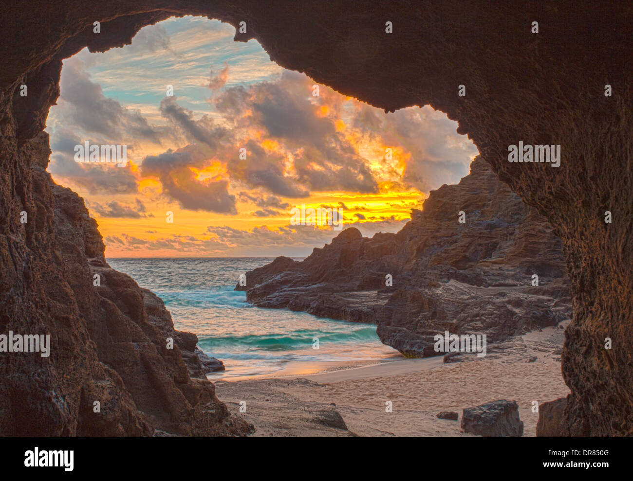 Beautiful sunrise viewed from a lava tube in Halona Cove, also known as ...