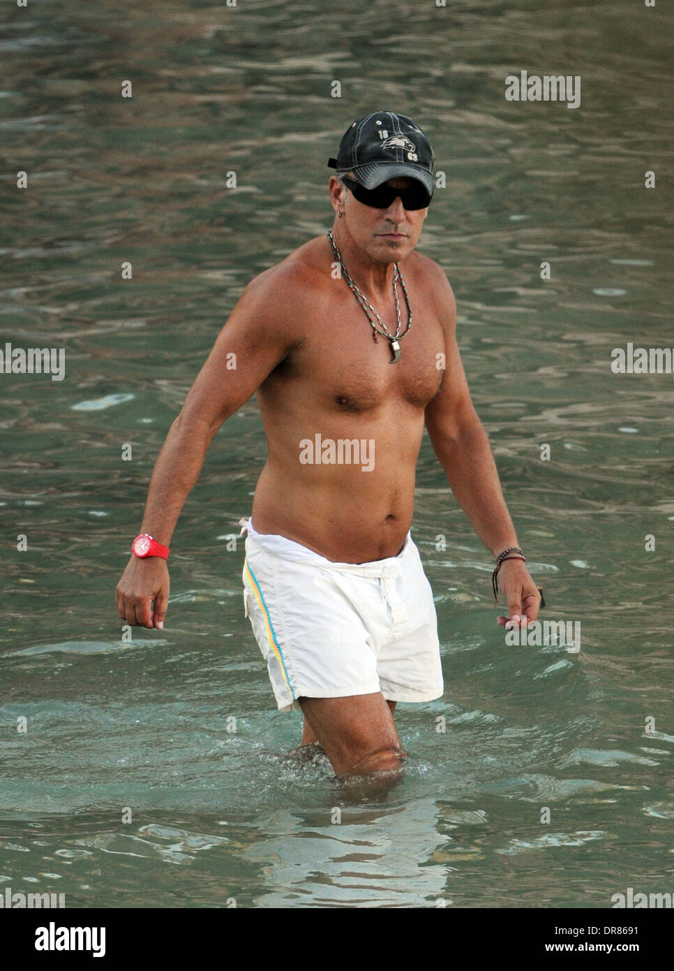 The singer Bruce Springsteen doing paddlesurf on a beach on holiday ...