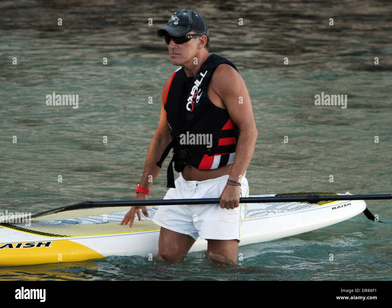 The singer Bruce Springsteen doing paddlesurf on a beach on holiday in ...
