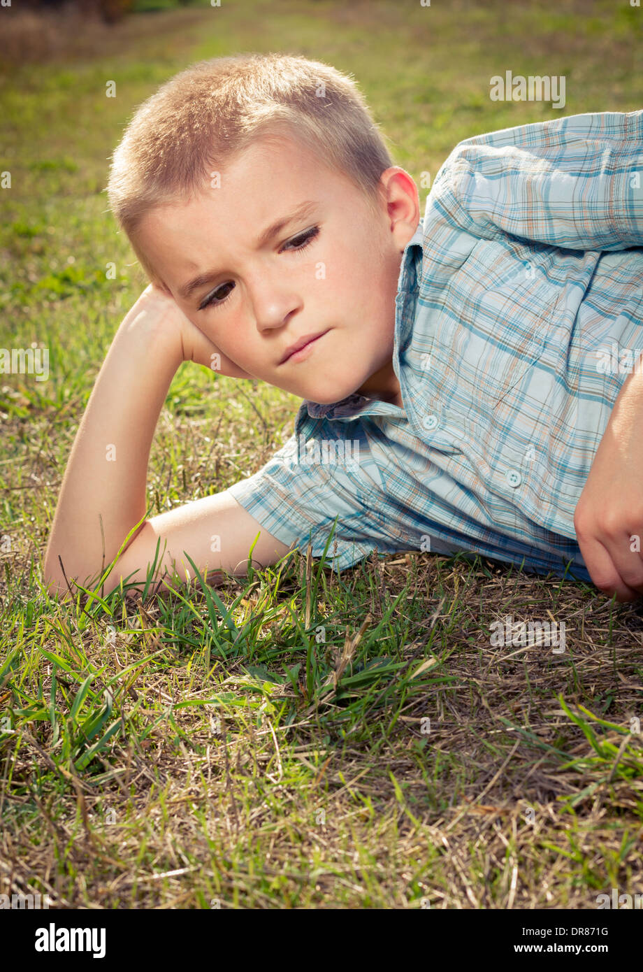 Young boy lying in grass Stock Photo - Alamy