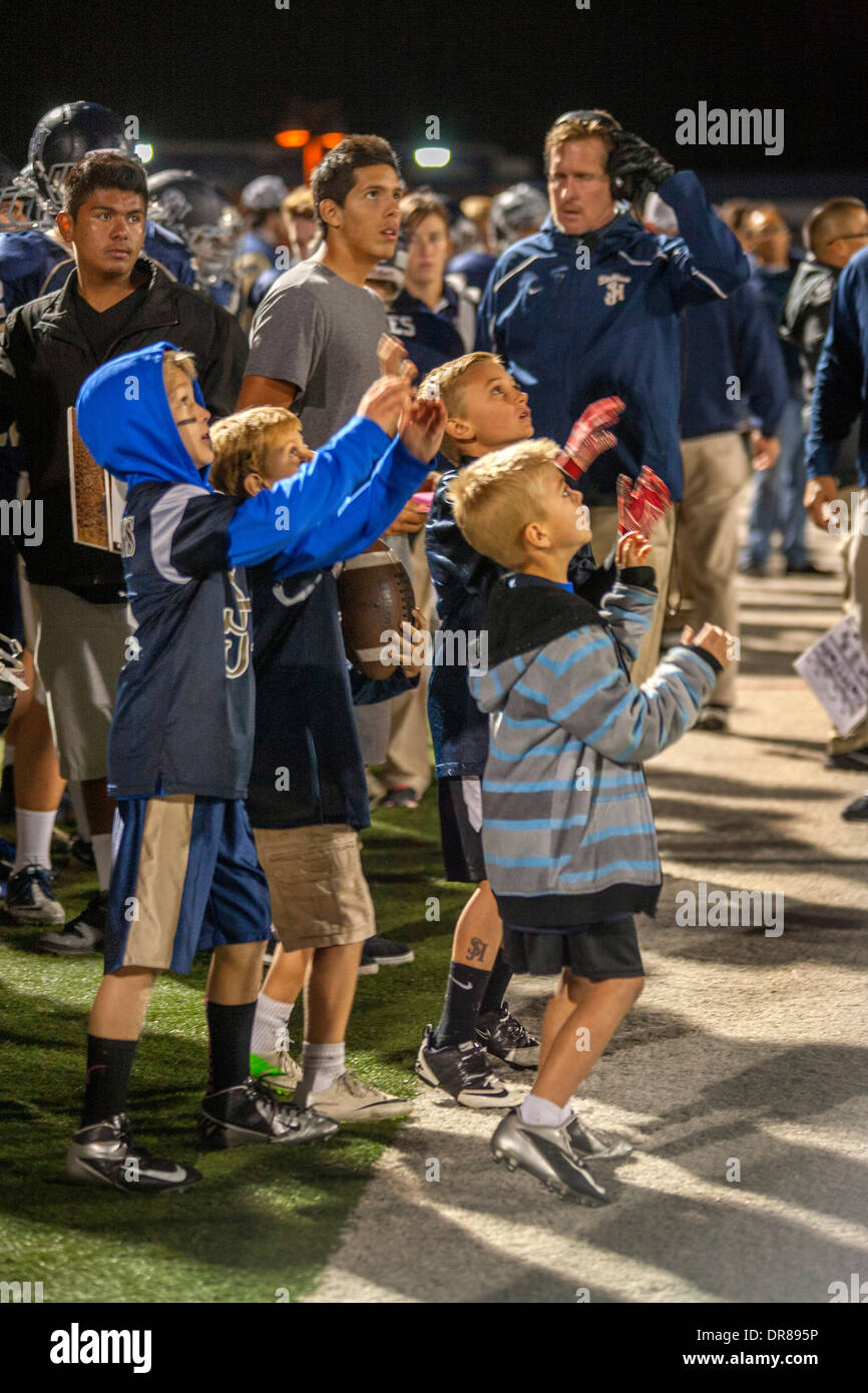 Goal boys on the sidelines reach out to catch a stray ball during a ...