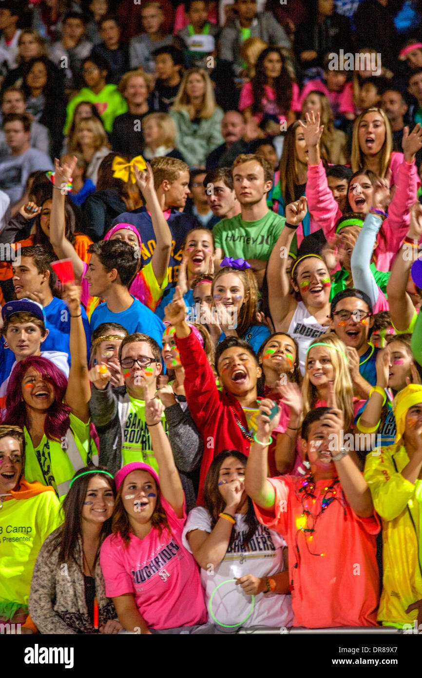 Local fans cheer their home team during a high school night football ...