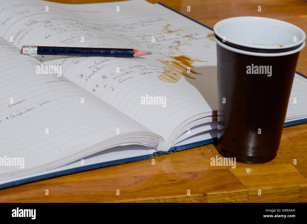 Hot drink liquid knocked over on to pages of work book Stock Photo - Alamy