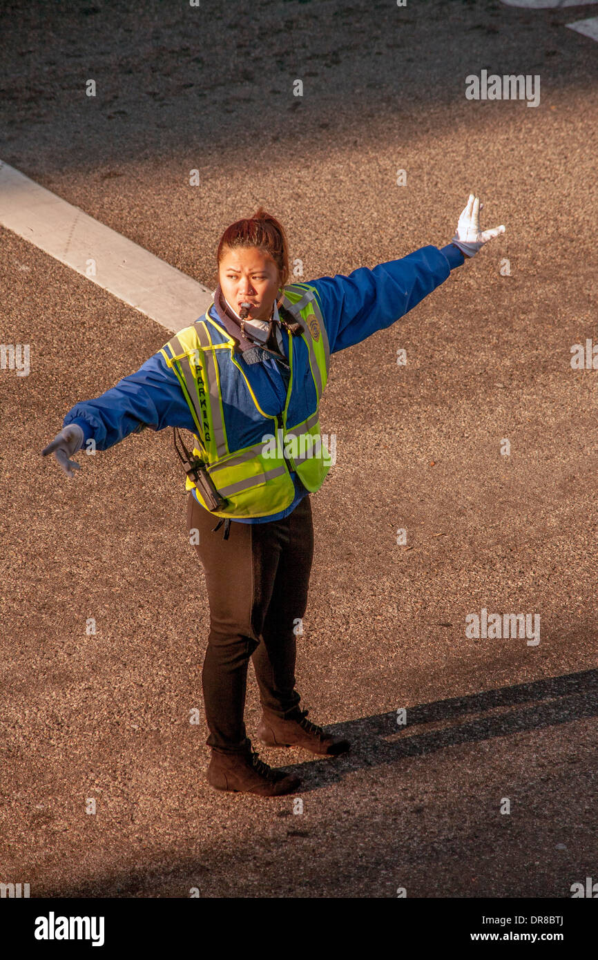 An Asian American police officer directs traffic on the campus of the ...