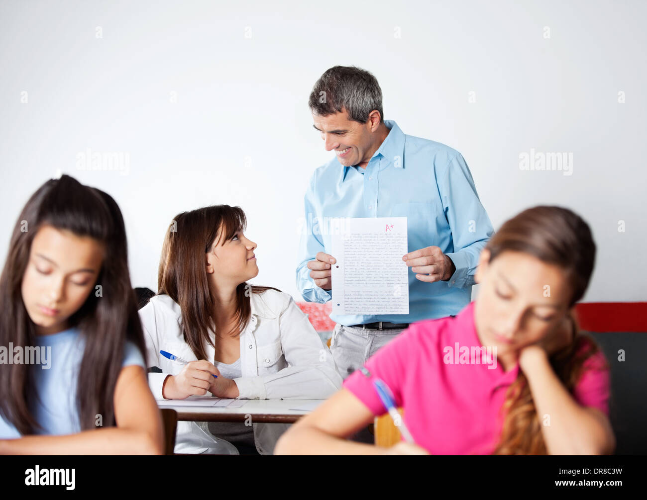 Girl showing schoolwork to friends hi-res stock photography and images ...